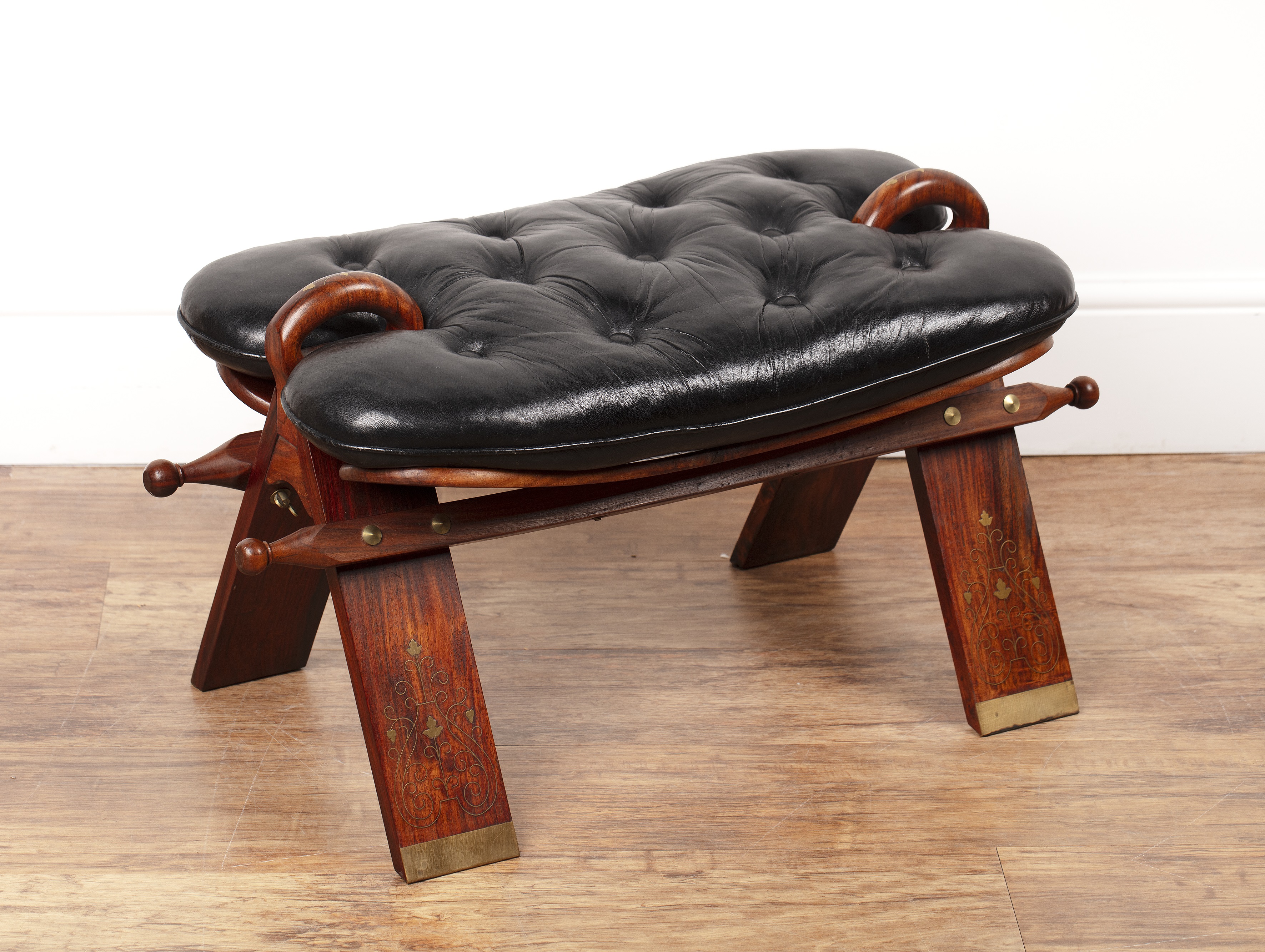 Lot 56 Camel saddle stool 20th Century with black